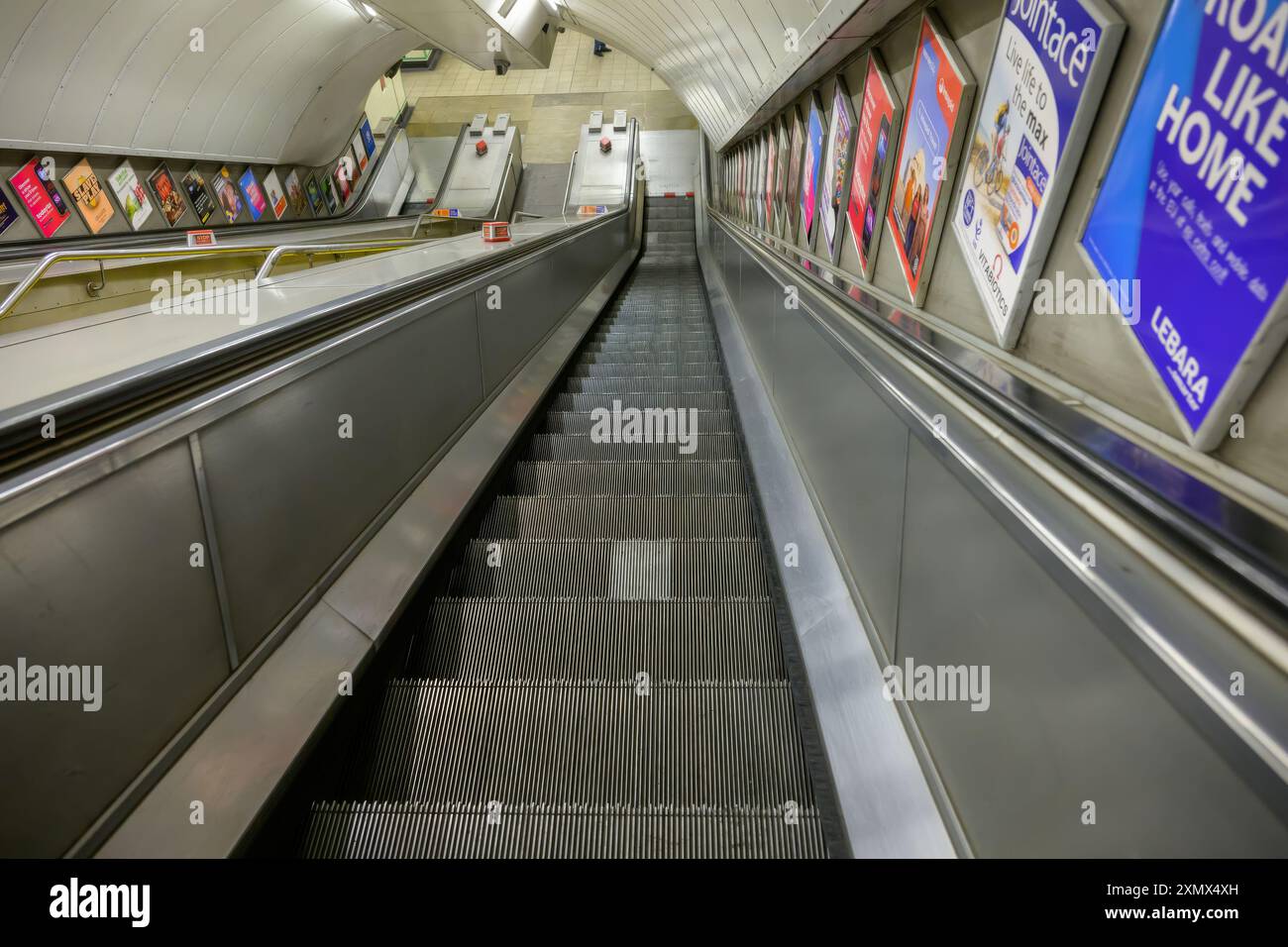 An empty escalator going down towards a London Tube station, empty ...