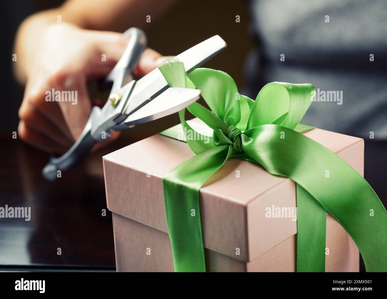 Decorating gift box with green ribbon using scissor Stock Photo - Alamy