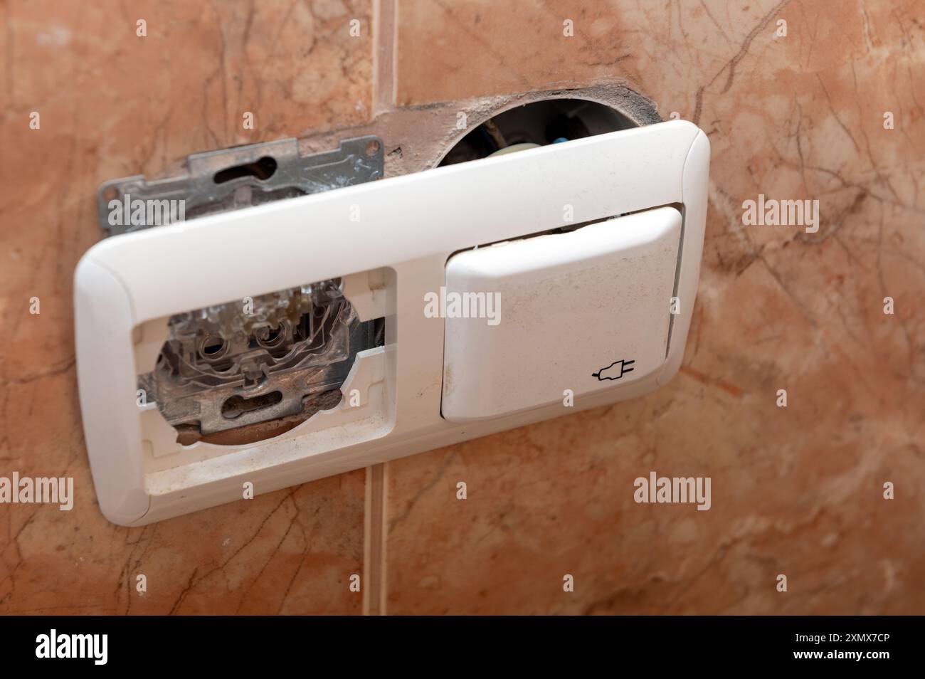 Broken socket on ceramic tile wall. Broken outlet. Concept of risk of ...