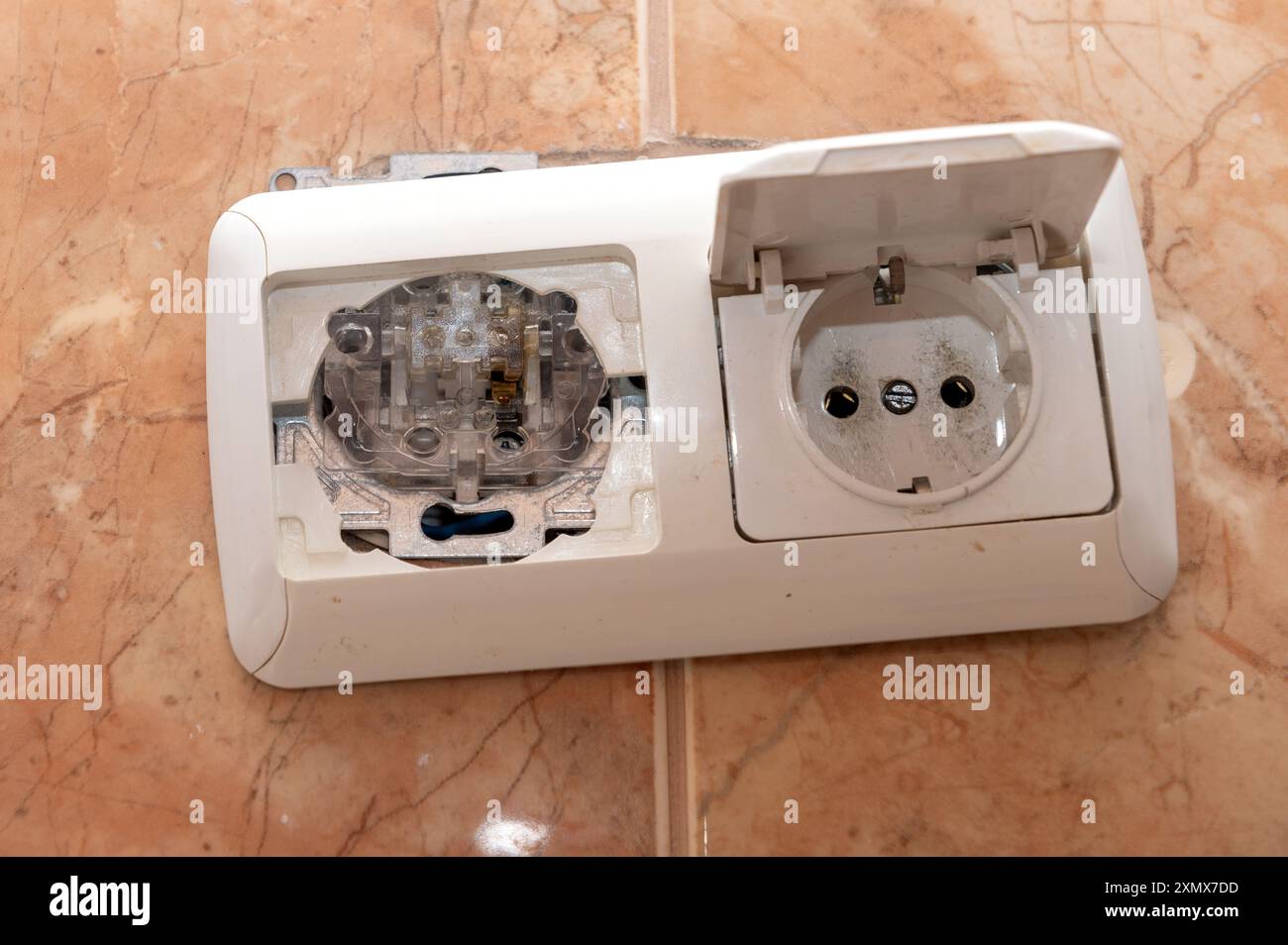Broken socket on ceramic tile wall. Broken outlet. Concept of risk of ...