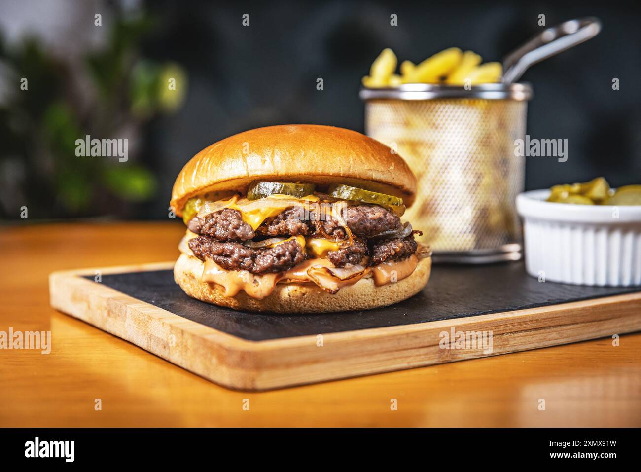 Delicious double beef burger standing on black slate with french fries ...