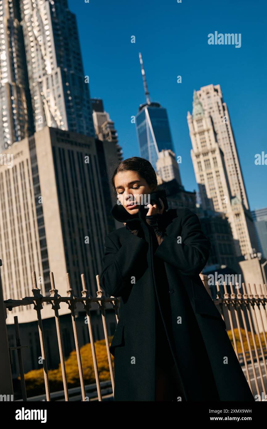 A young woman stands in a New York City street, shrouded in shadow ...
