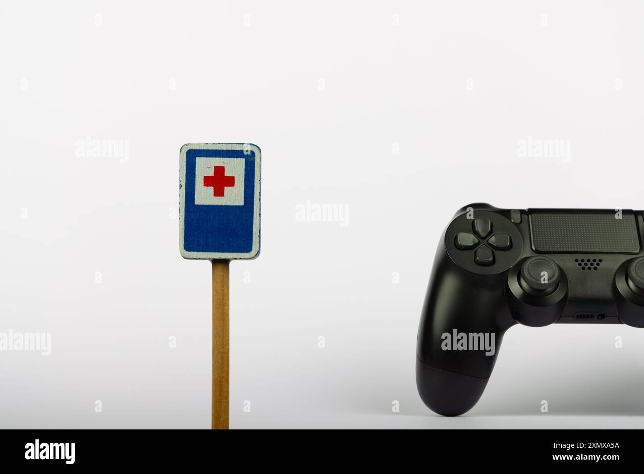The image shows a wooden toy hospital sign and a video game controller ...