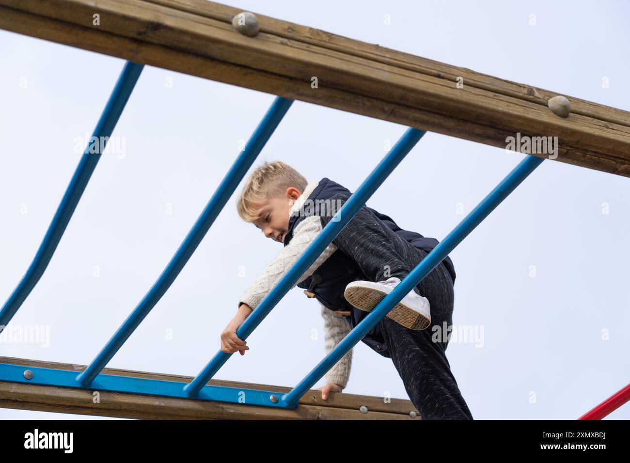 Child playing climbing a playground structure Stock Photo - Alamy