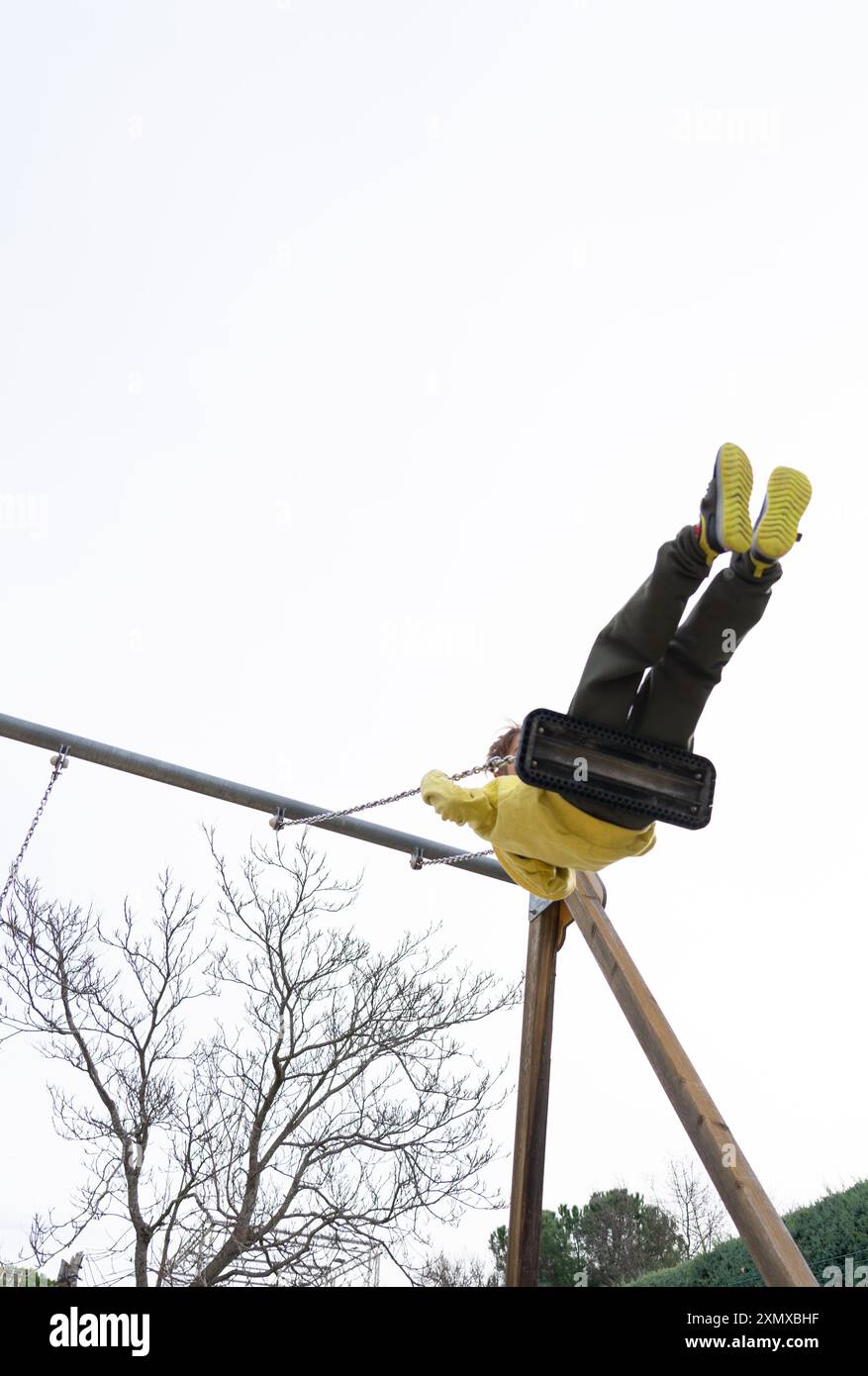Child swinging high on a playground swing with copy space Stock Photo - Alamy