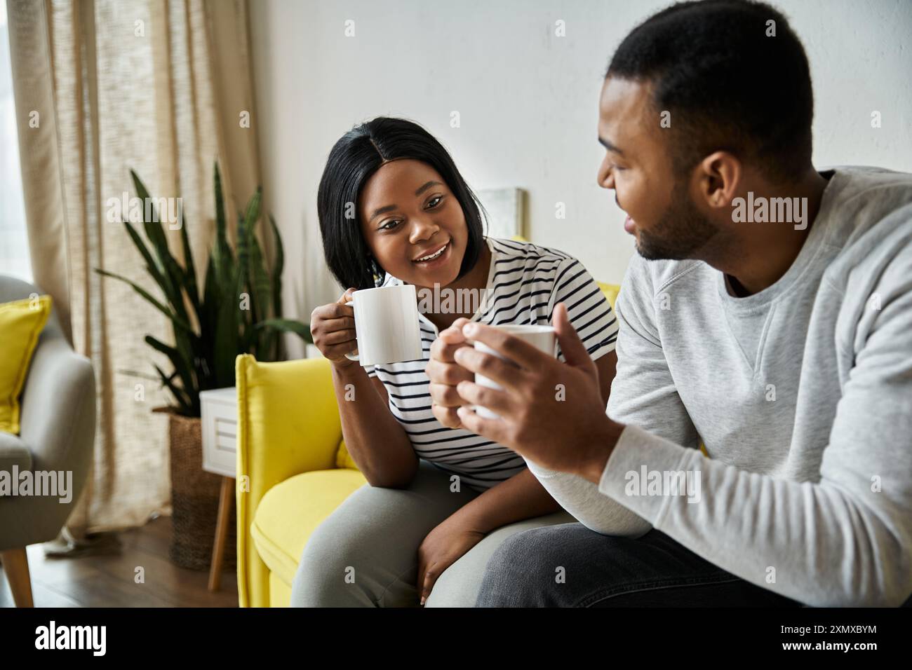 A loving couple shares a warm moment together at home, enjoying a ...