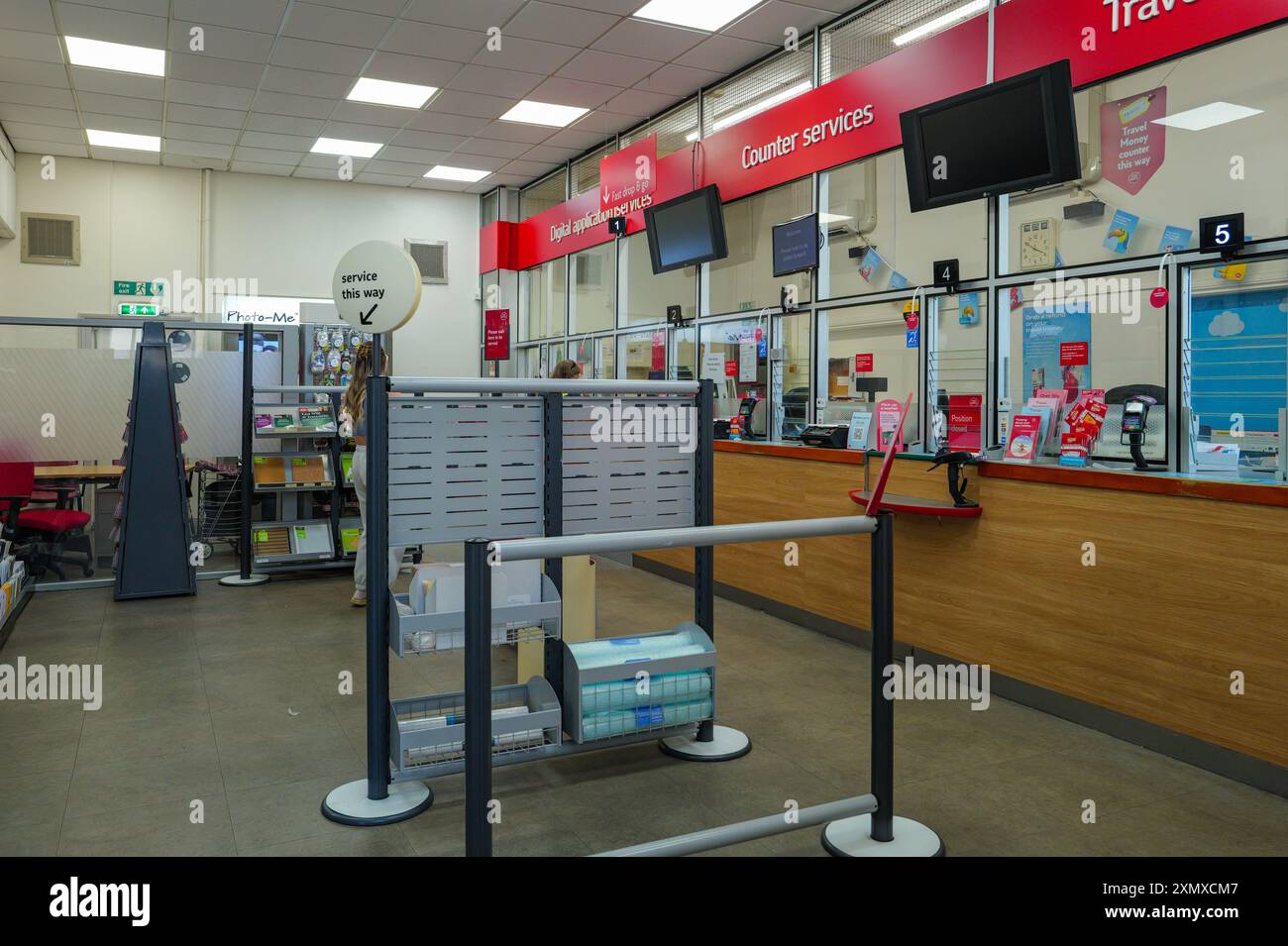 People queuing and waiting to be served at a UK post office in South ...