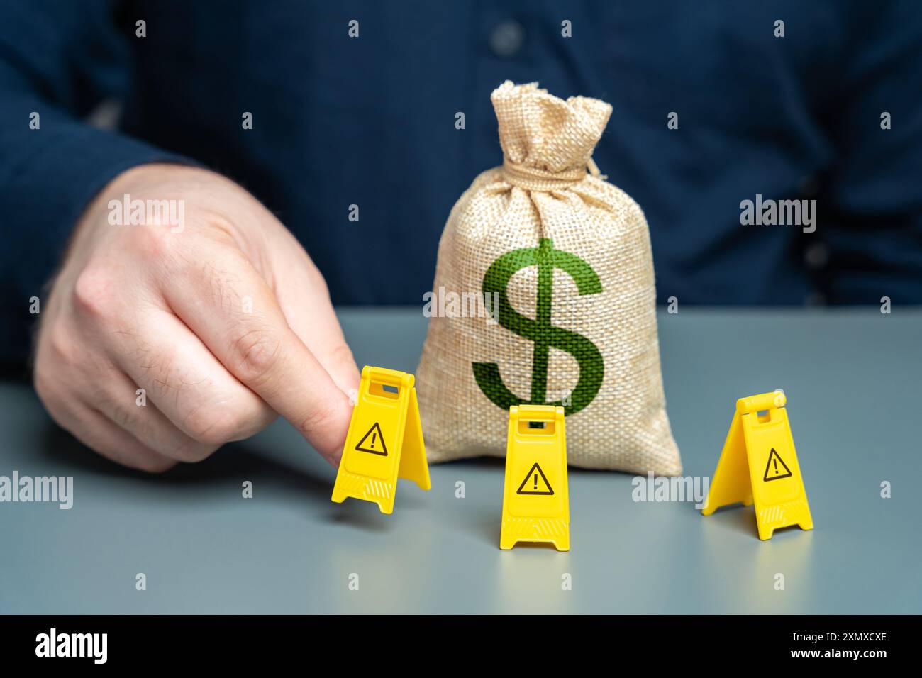 A man surrounds a dollar money bag with restrictive signs. The concept ...