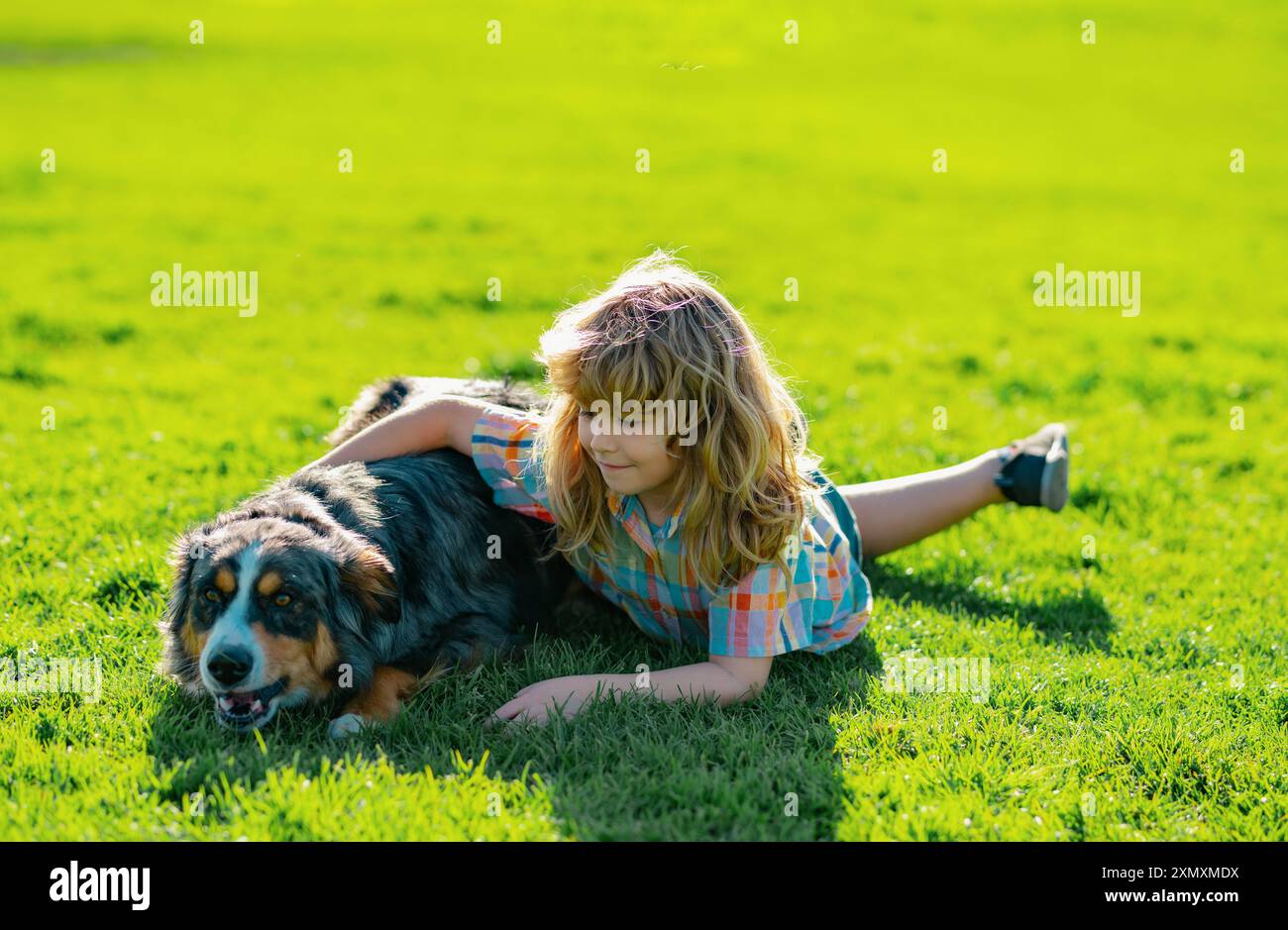 Child hugging a dog in outdoor. Kid boy lovingly embraces his pet dog ...
