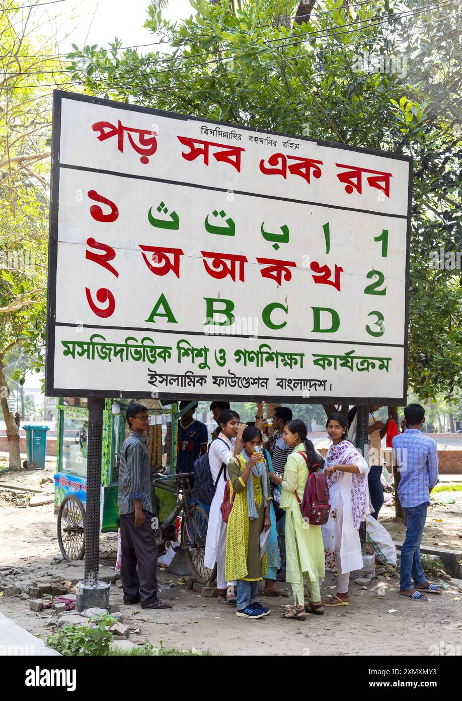 Bangladeshi students under a billboard promoting muslim education ...