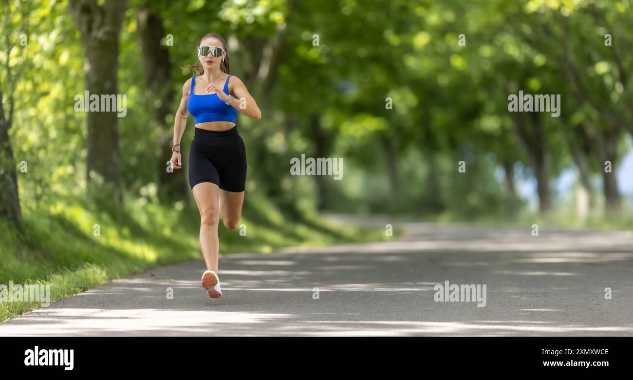 Fit young woman jogging in park smiling happy running and enjoying a ...