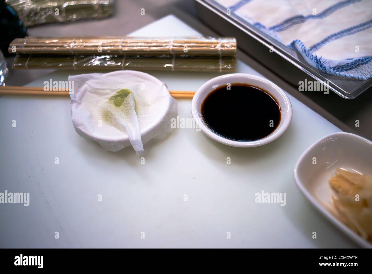 A sushi workshop table featuring chopsticks, a sushi rolling gadget ...