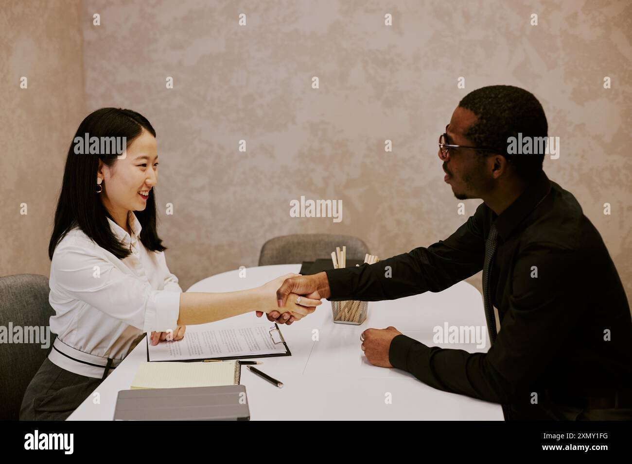 Young Asian female HR specialist and African American applicant doing ...