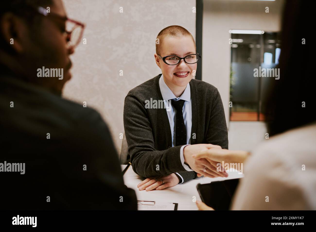 Over shoulder shot of cheerful young woman with buzz cut doing ...