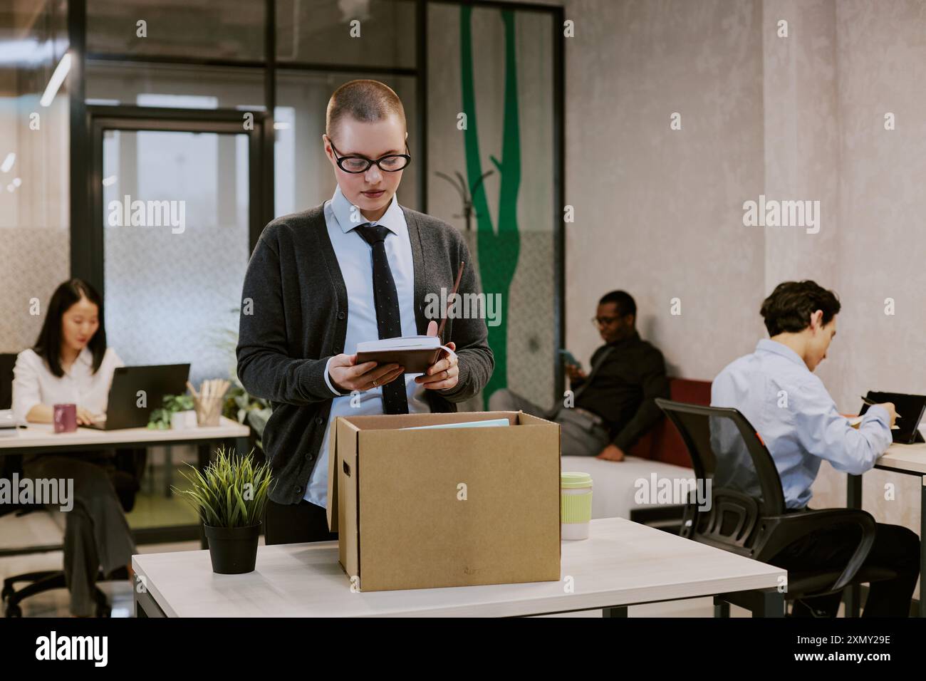 Young female new employee with buzz cut standing at office desk ...