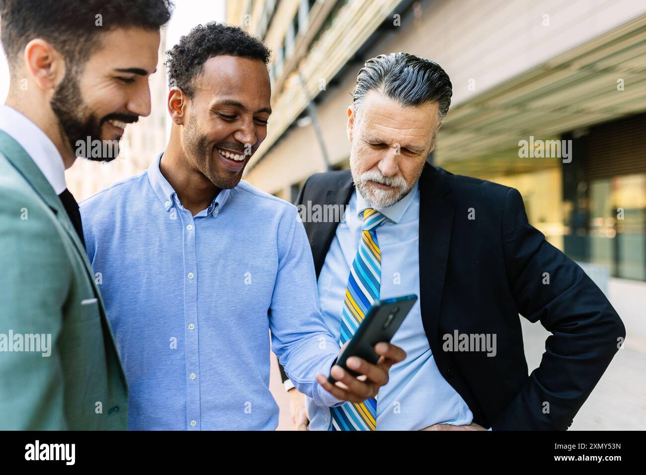 Successful group of business people using smart phone at city street ...