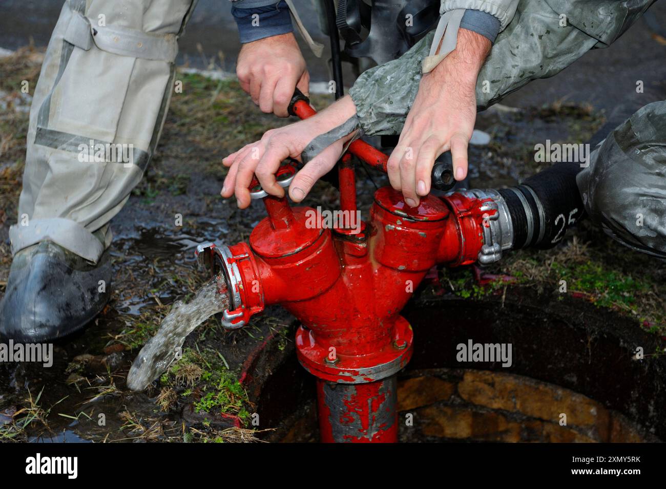 Rescuer hands in protective costume turning valve of fire hydrant to ...