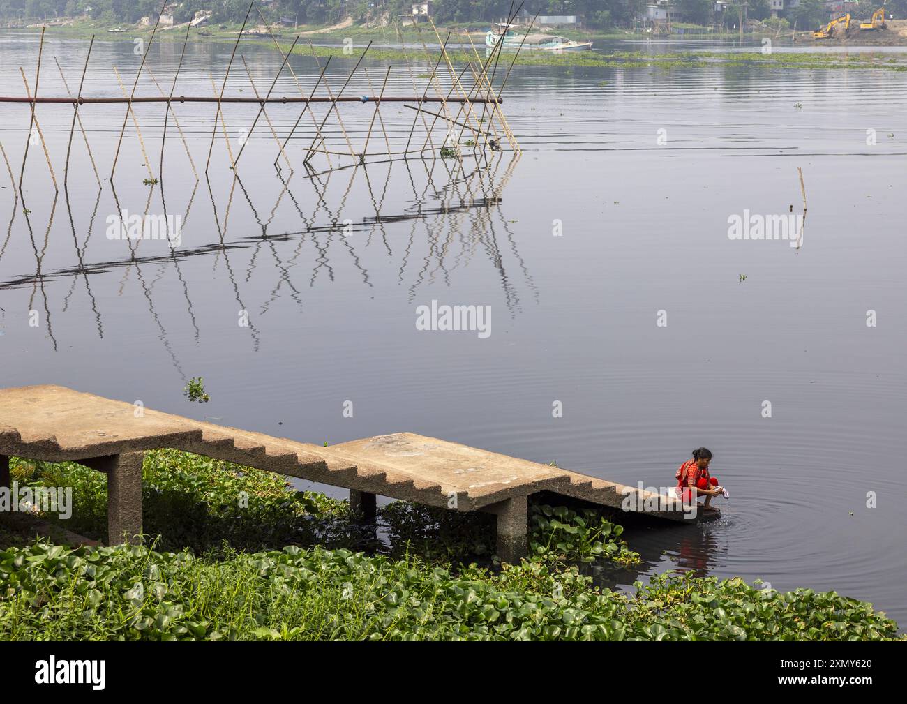 Bangladeshi woman washing clothes in a river, Dhaka Division, Rupganj ...