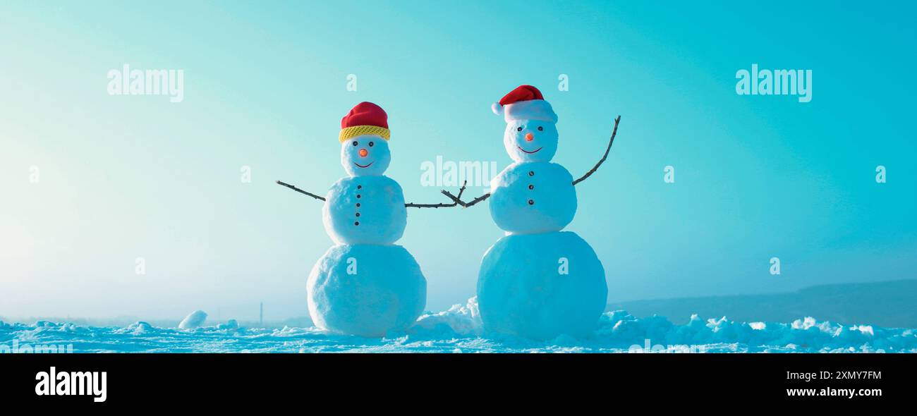 Couple of two snowman holding hands outdoors. Snowman on the snow ...