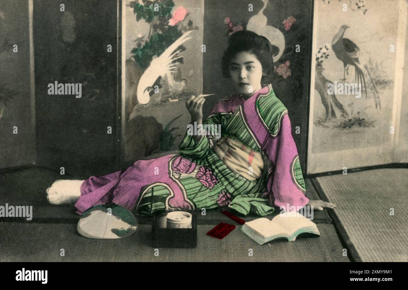 Geisha seated before a folding screen featuring cranes Stock Photo - Alamy