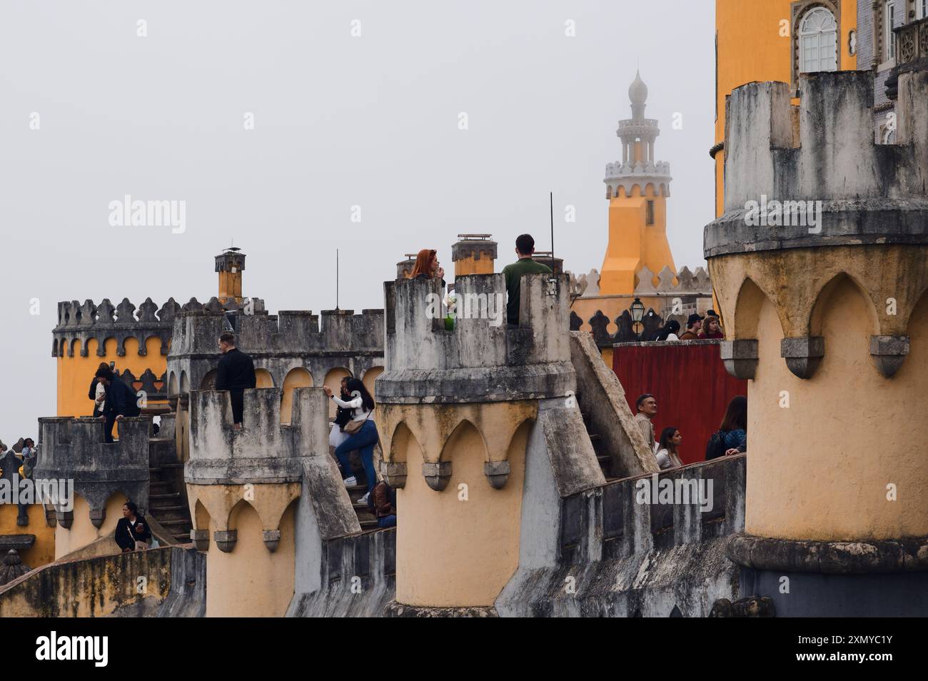 Visitors explore the vibrant yellow towers with battlements of Pena ...