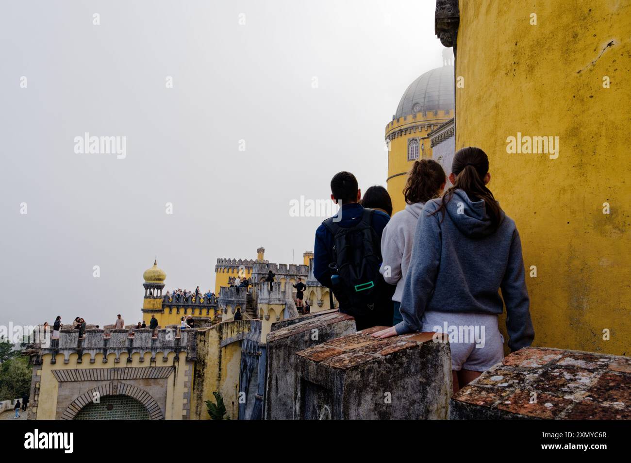 Visitors explore the vibrant yellow towers and battlements of Pena ...