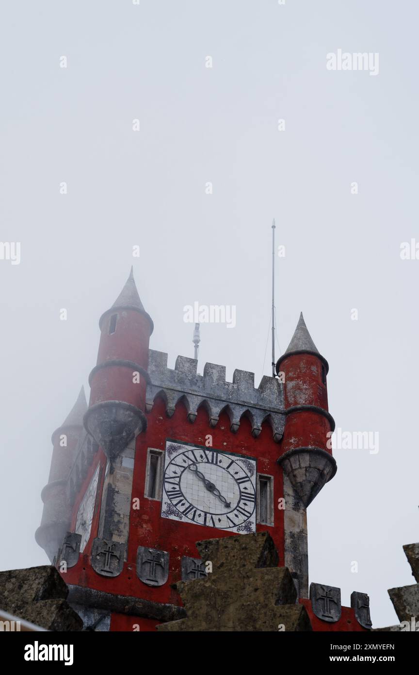 The red clock tower of Pena Palace pierces the mist on a foggy day ...