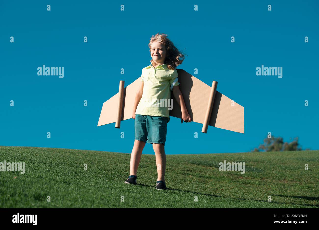 Funny boy with toy cardboard airplane wings fly. Startup freedom ...