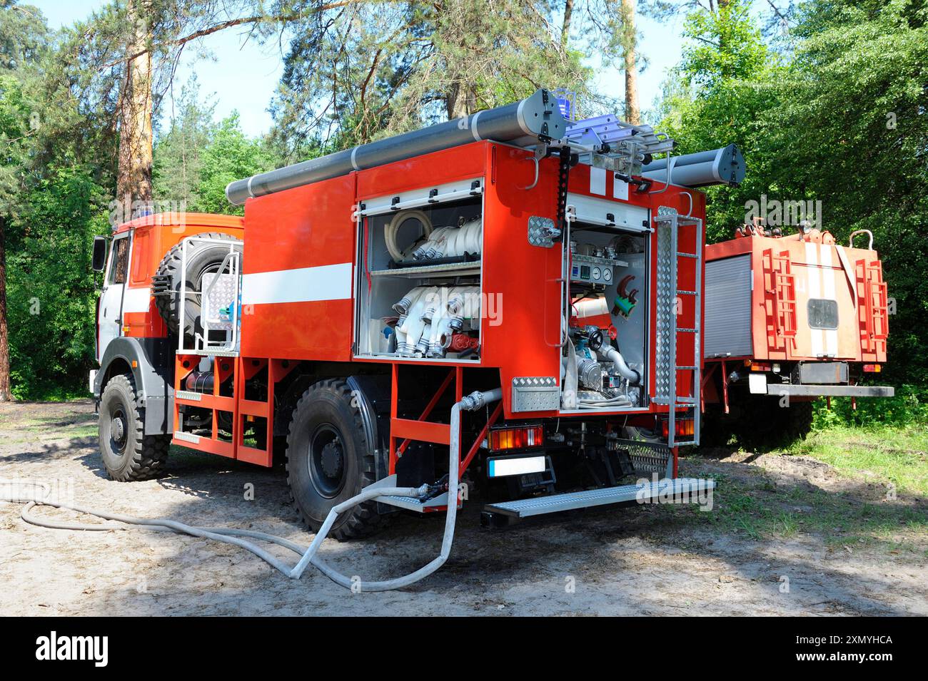 Fire engine parked in a forest, hoses connected, fire-fighting ...