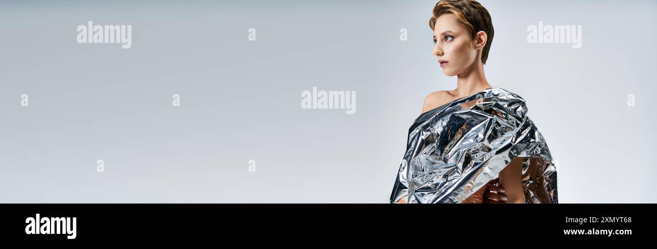 A woman poses in a studio, draped in a silver, sustainable fabric Stock ...