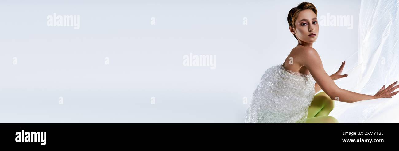 A woman poses in a studio, draped in a sustainable fabric Stock Photo ...