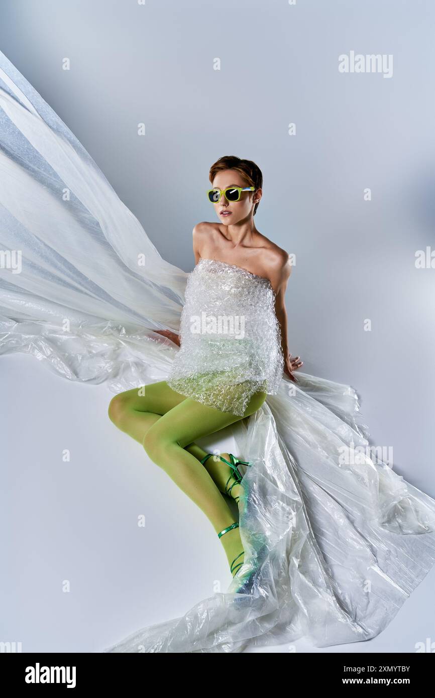 Woman in bubble wrap dress poses on white background, surrounded by ...
