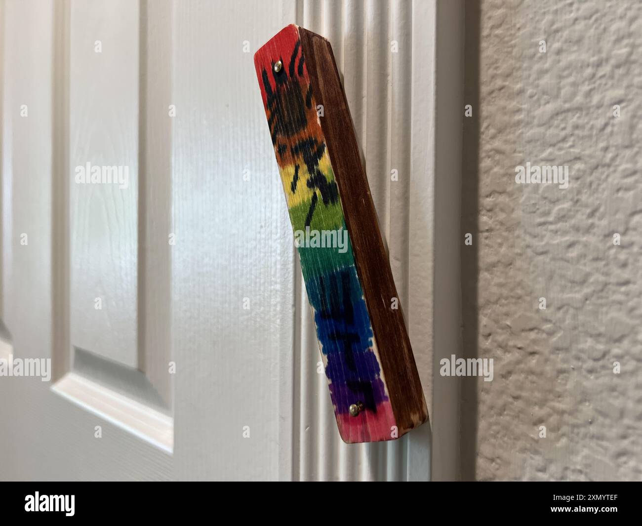 USA. 01st June, 2024. Close-up of a colorful, handmade mezuzah affixed ...
