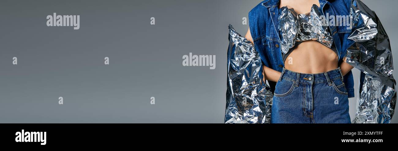 A woman wears a denim jacket and jeans with a silver reflective fabric ...