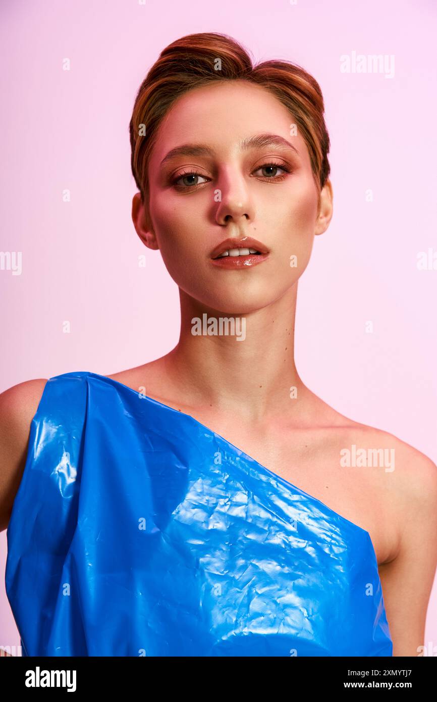 A woman poses in a stylish, blue, one-shoulder dress made from recycled ...
