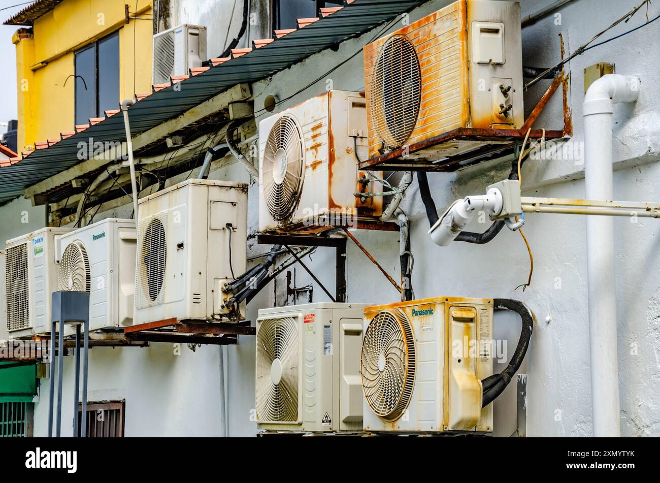 Old, weathered air conditioning units on the exterior wall of a ...