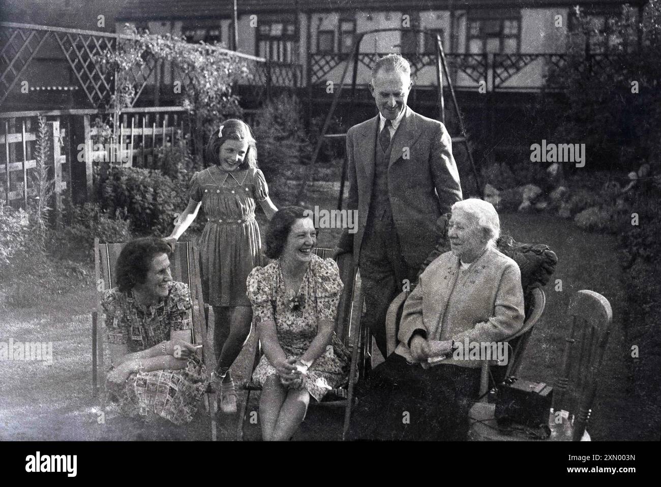 1940s, historical, in a back garden, a family laughing as they enjoy ...
