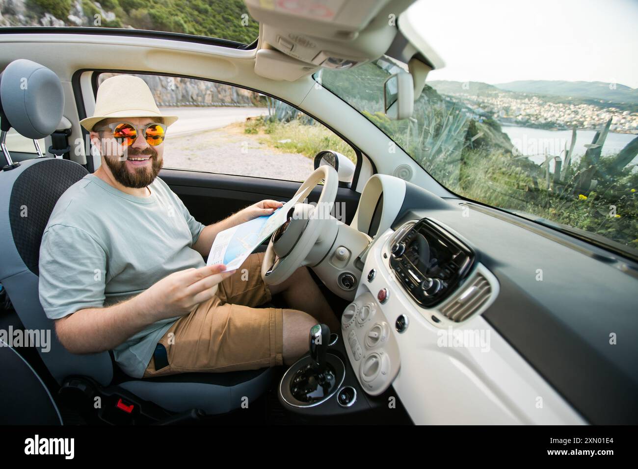 Hipster man looking on location navigation map in car, tourist traveler ...
