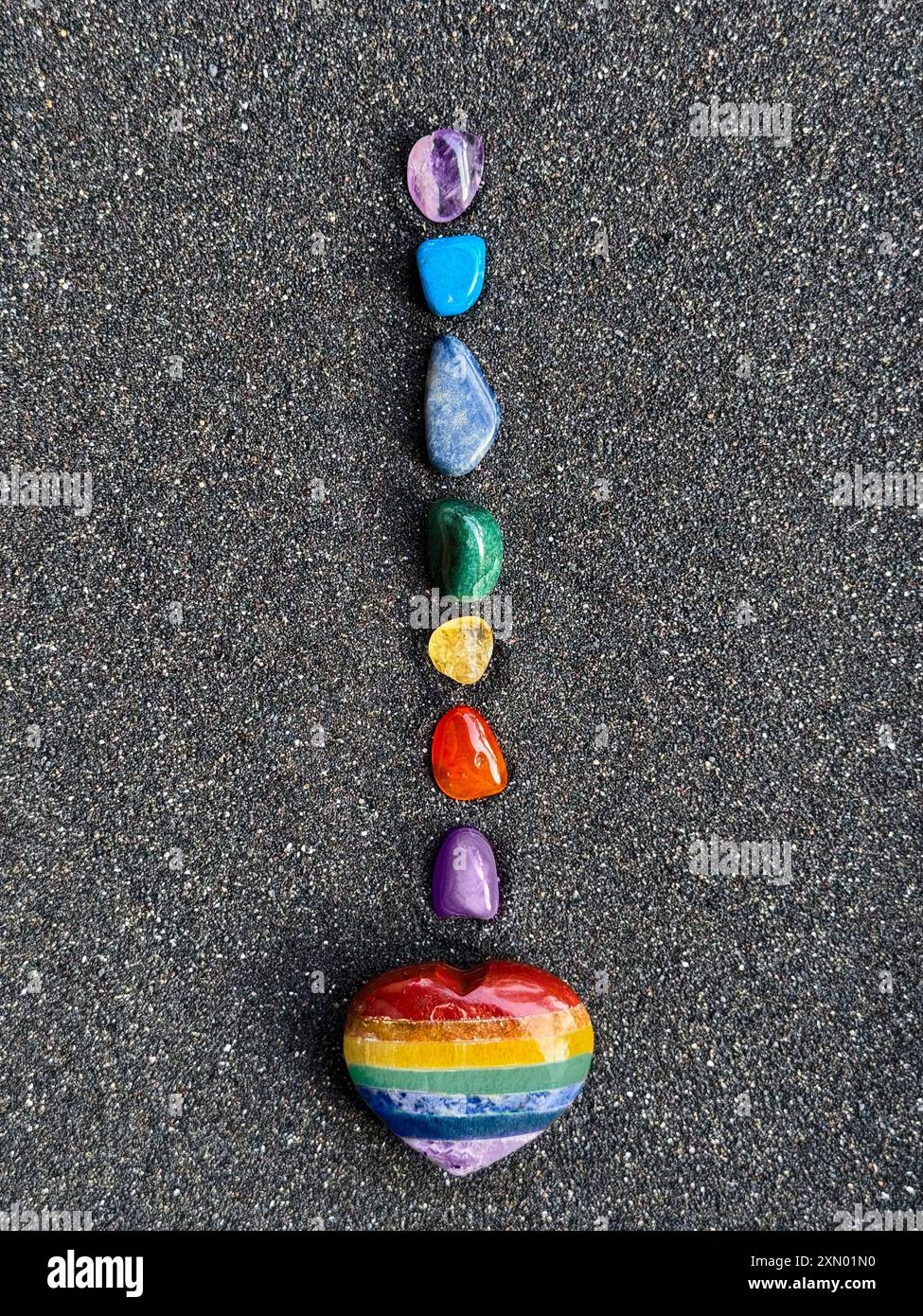 Colorful Chakra Stones Aligned on Dark Sand Background in Vertical ...