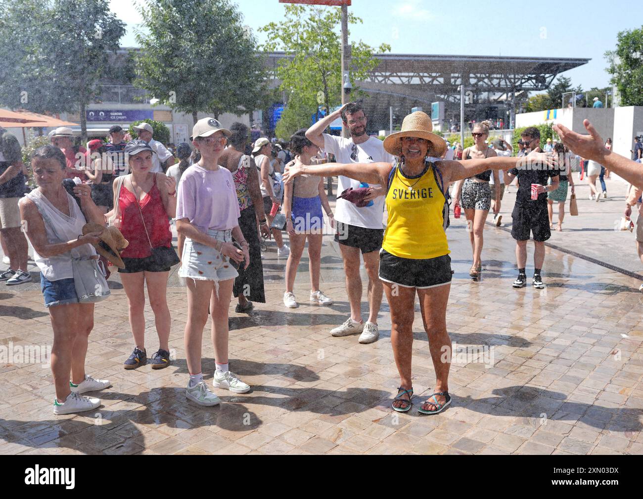 Spectators cool off in a mist of water at Roland-Garros on the fourth ...