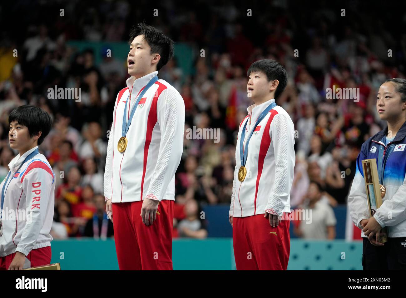 China's Wang Chuqin, second left, and Sun Yingsha sing the national ...