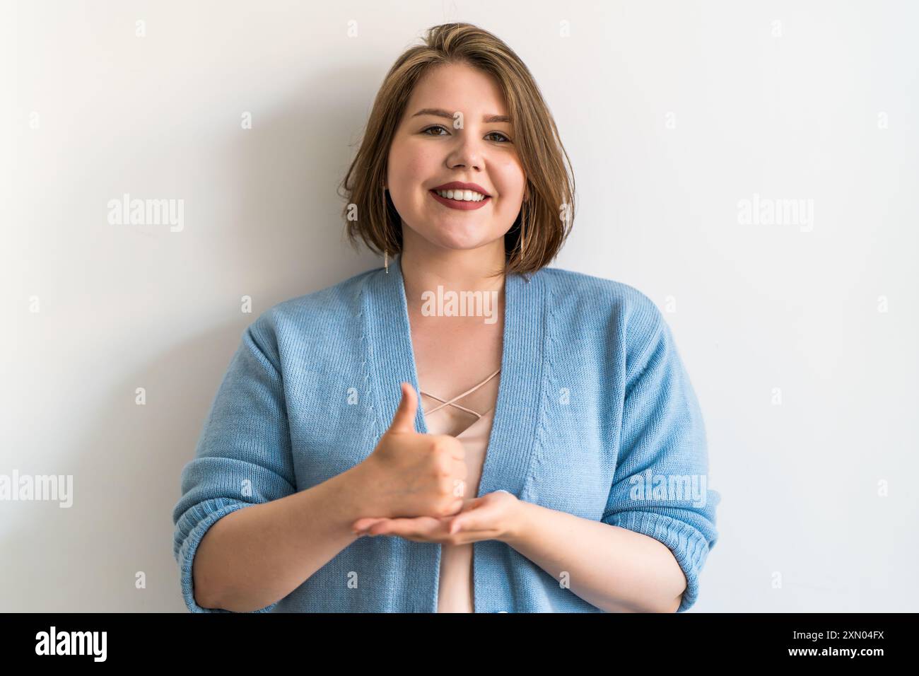 Plus size woman showing thumbs up sign in sign language, expressing ...