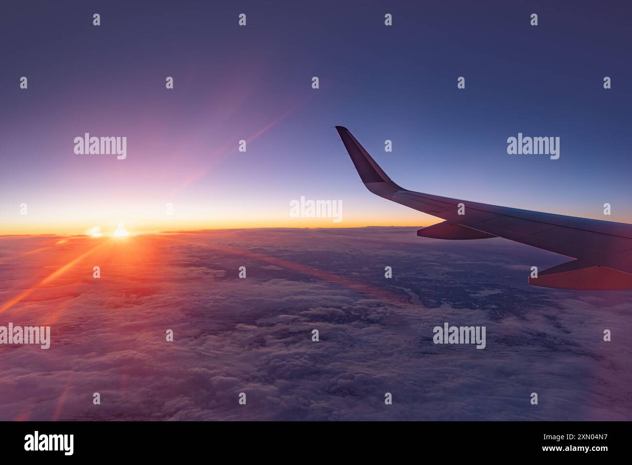 Airplane flying low over snowy mountains and preparing for landing to ...