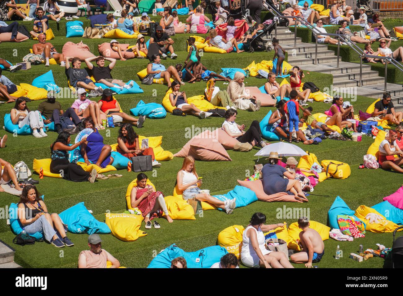 London, UK. 30 July 2024. Sun seekers soaking the sunshine in Granary ...