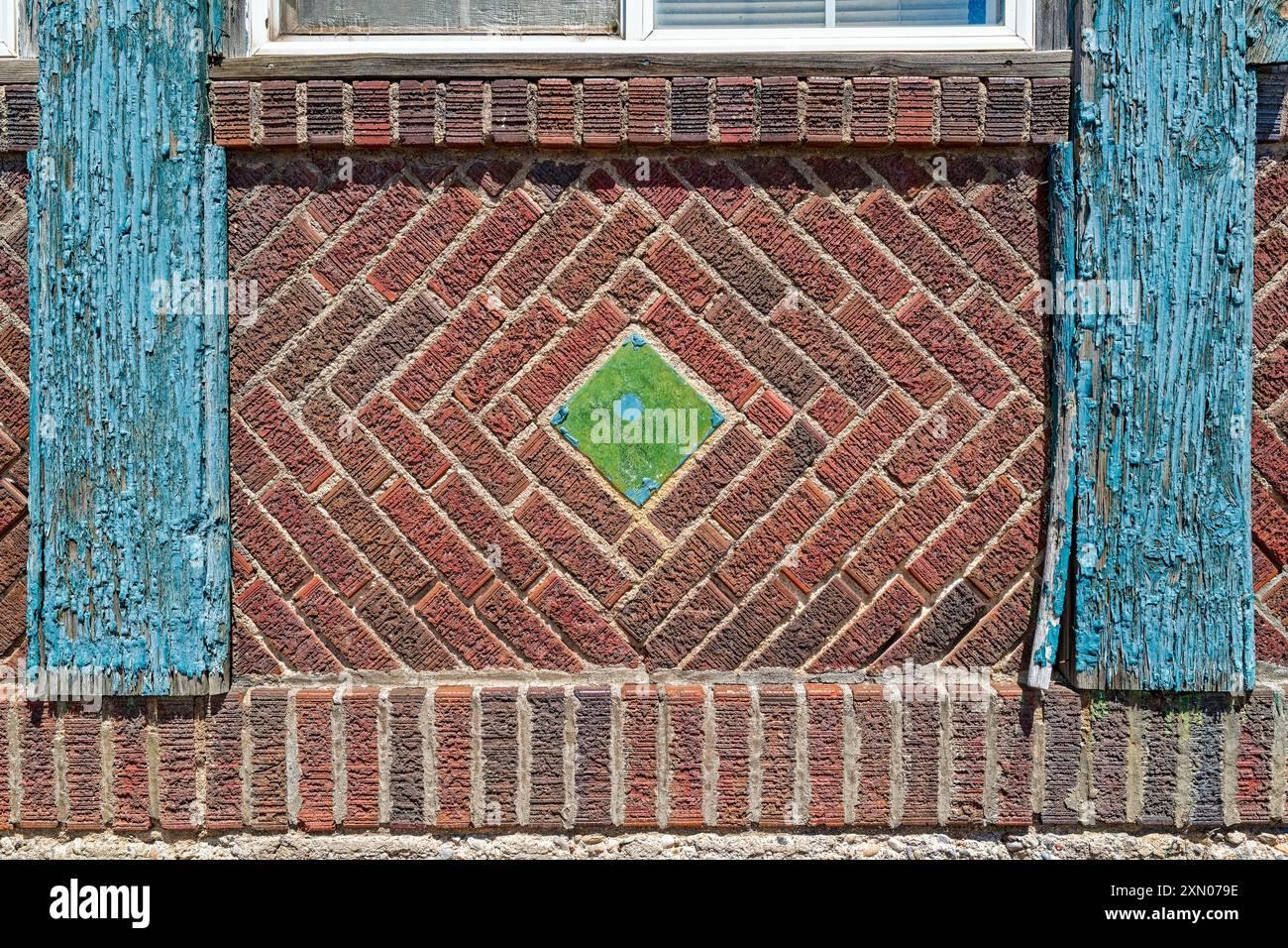 Diamond shaped tile inlay on the exterior brick wall of an old building ...