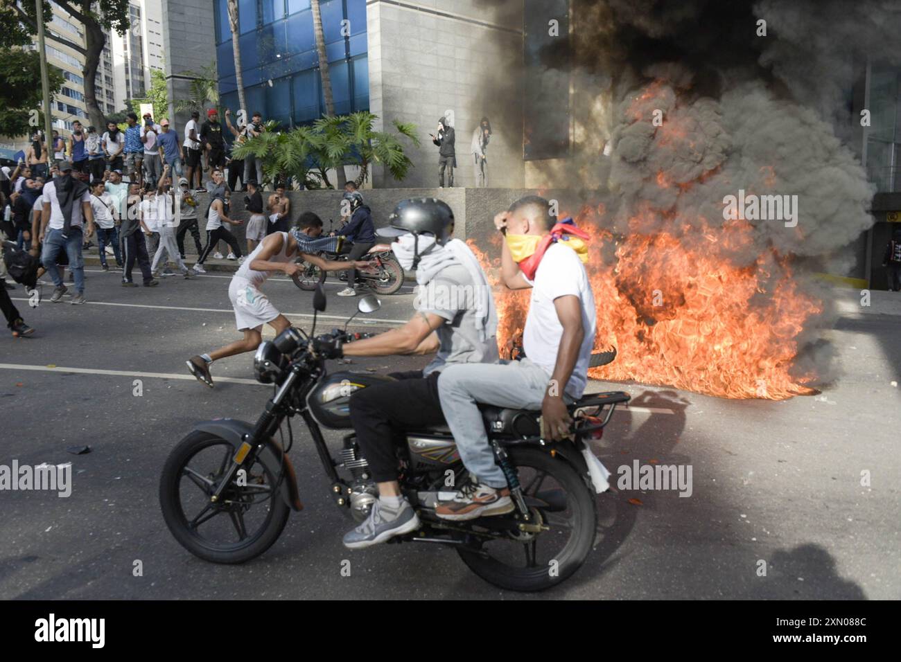 A motorcycle seen passing by a bonfire set by rotesters for the re ...