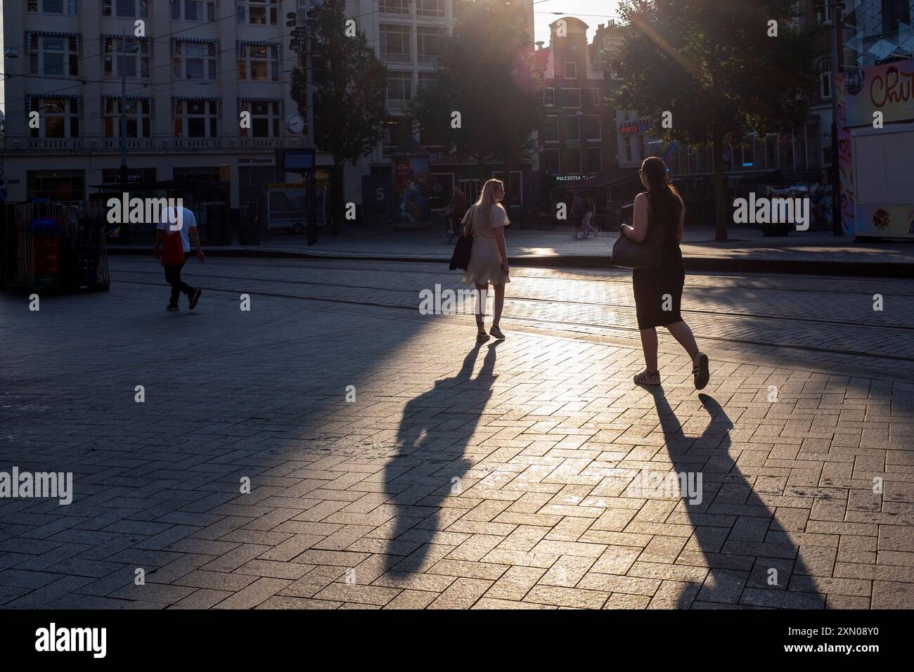 People cast shadows on their morning walk to work in the quiet streets ...