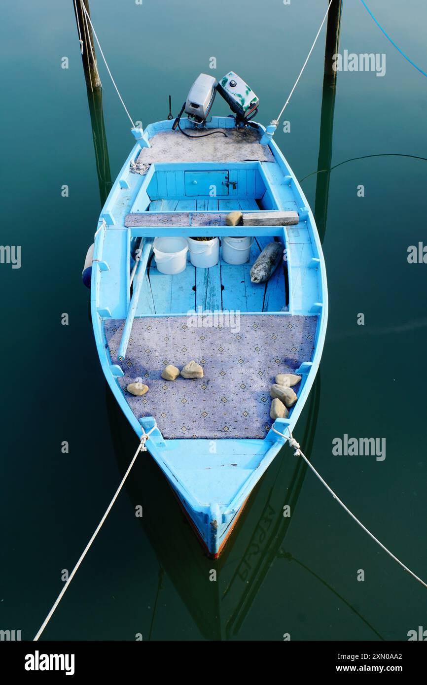 The stillness of the sea mirrors the calmness of the anchored boat ...