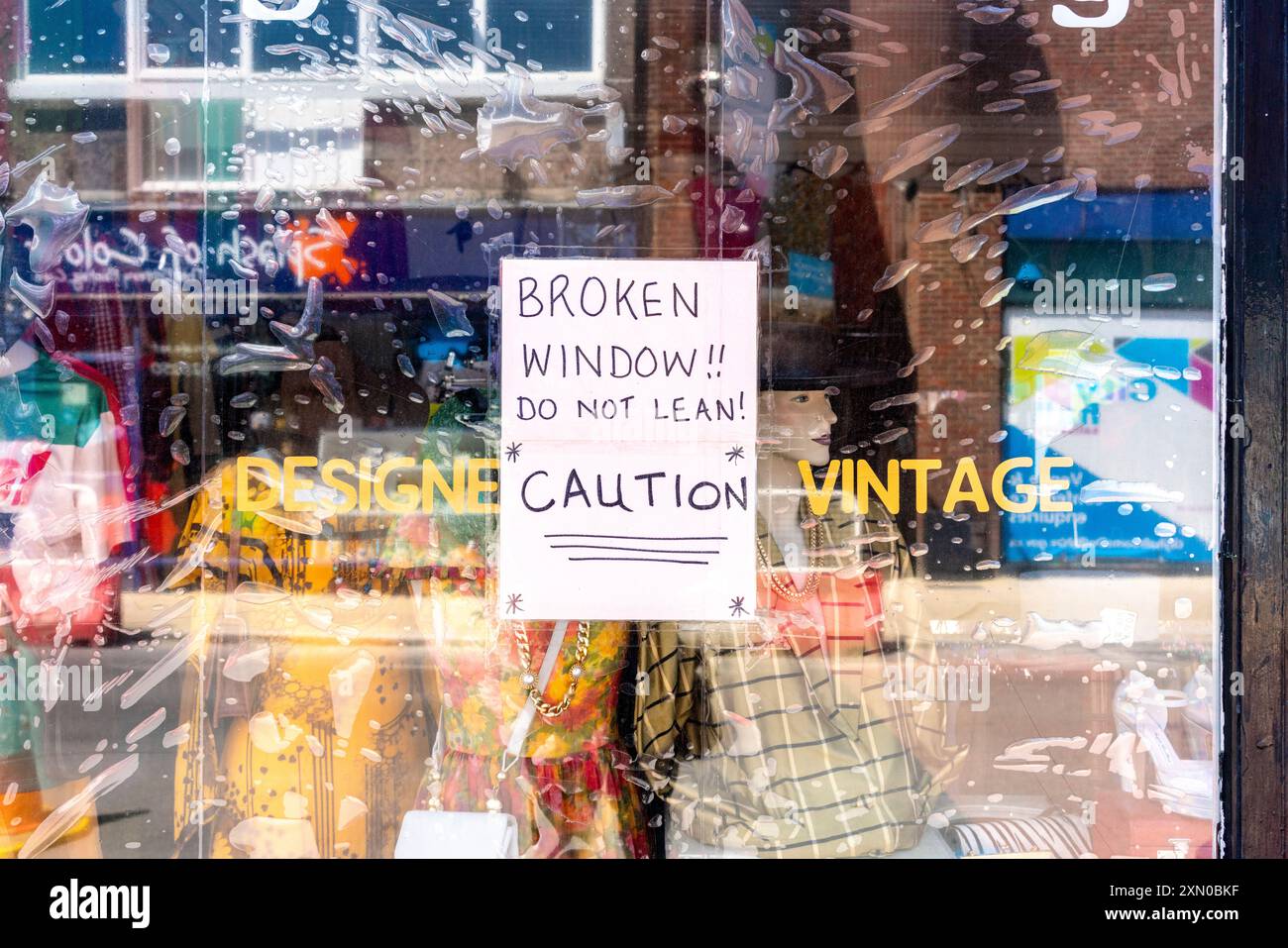 Broken shop window covered by polythene safety film and sign Stock ...