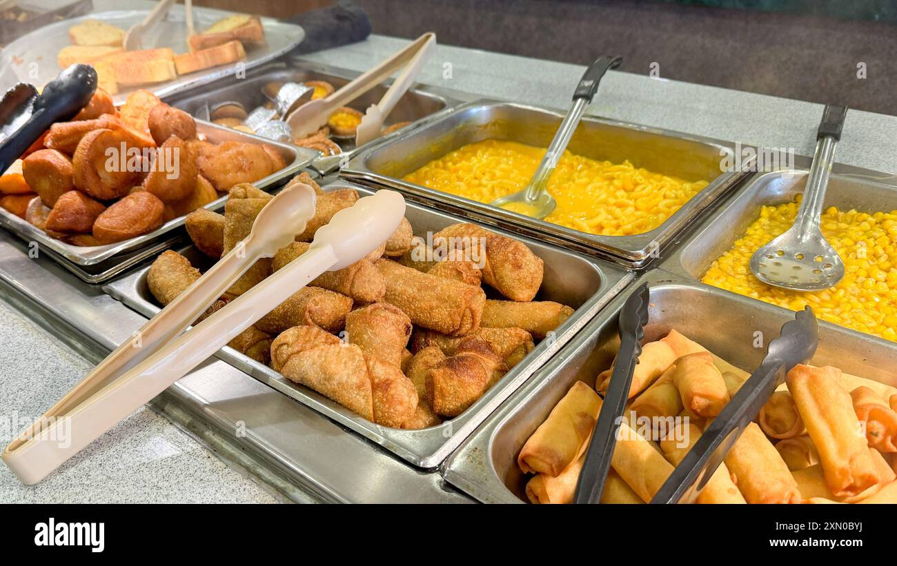 a buffet-style food setup with trays of various fried items, such as ...